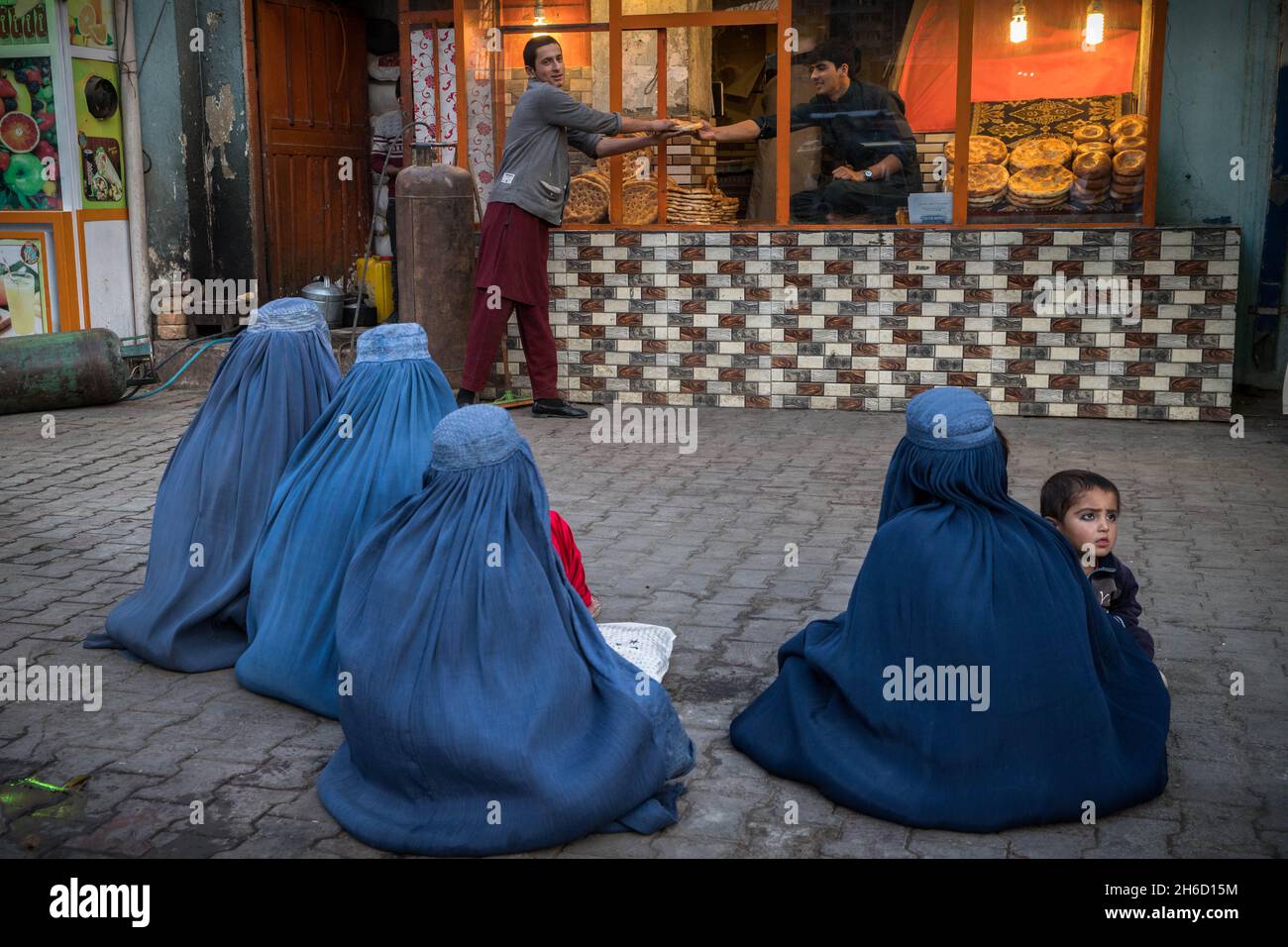 EDITORIAL USE ONLY - Burqa-clad Afghan women wait for donations of ...