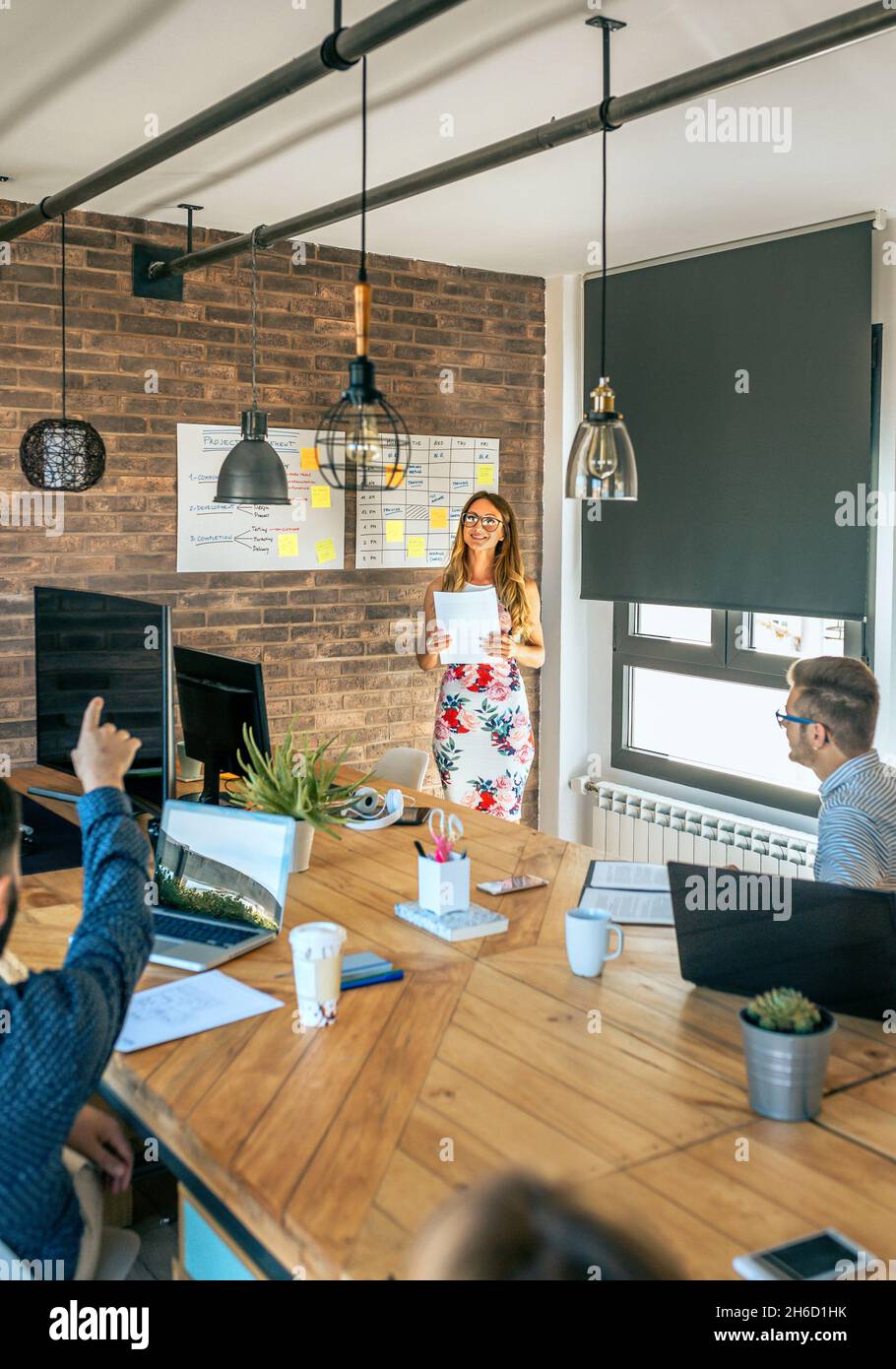 Female manager answering questions in a work meeting Stock Photo - Alamy