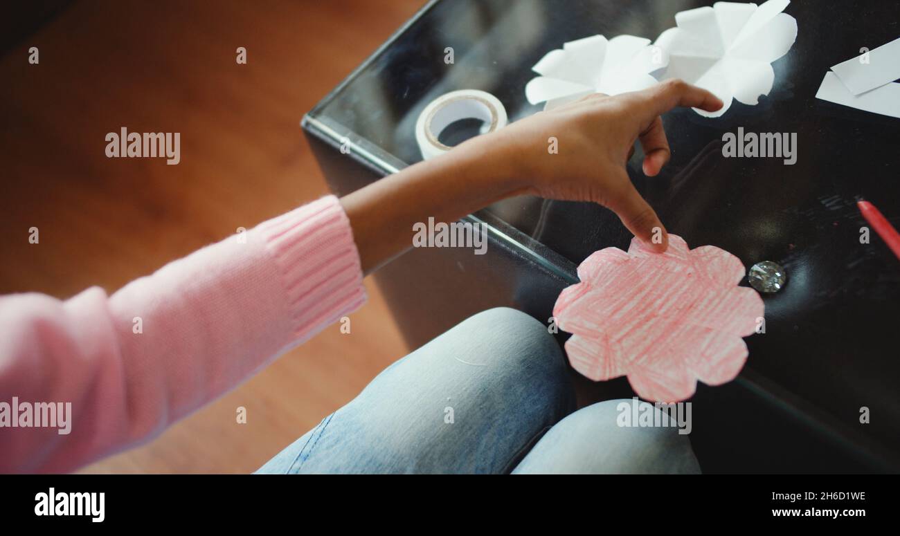 Little girl filling flower shaped paper with colors Stock Photo - Alamy