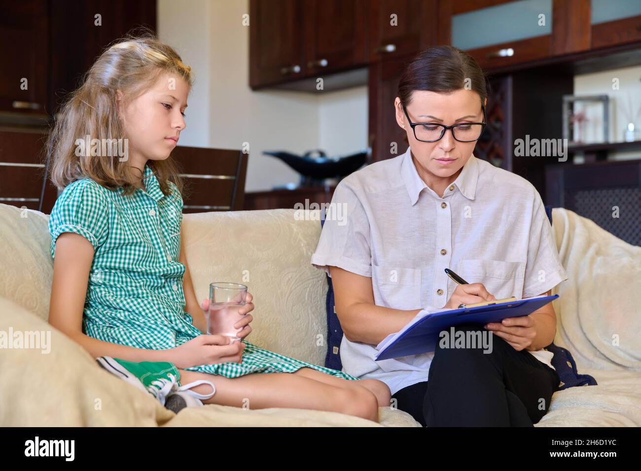 Serious sad child girl and female psychologist teacher at session Stock ...