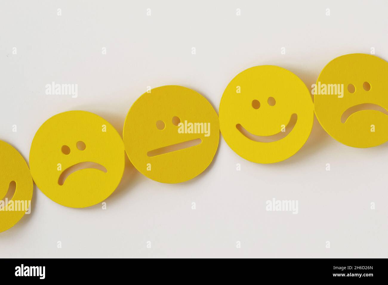 Chain of paper faces with positive, neutral and negative expression on ...