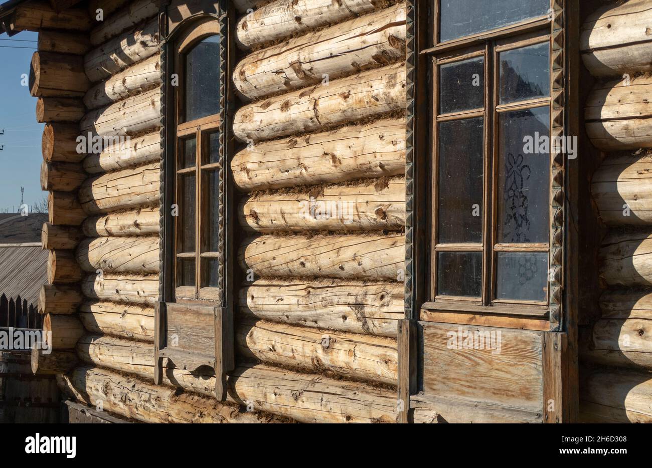 A fragment of a wooden hut made of round logs in a village in Siberia ...