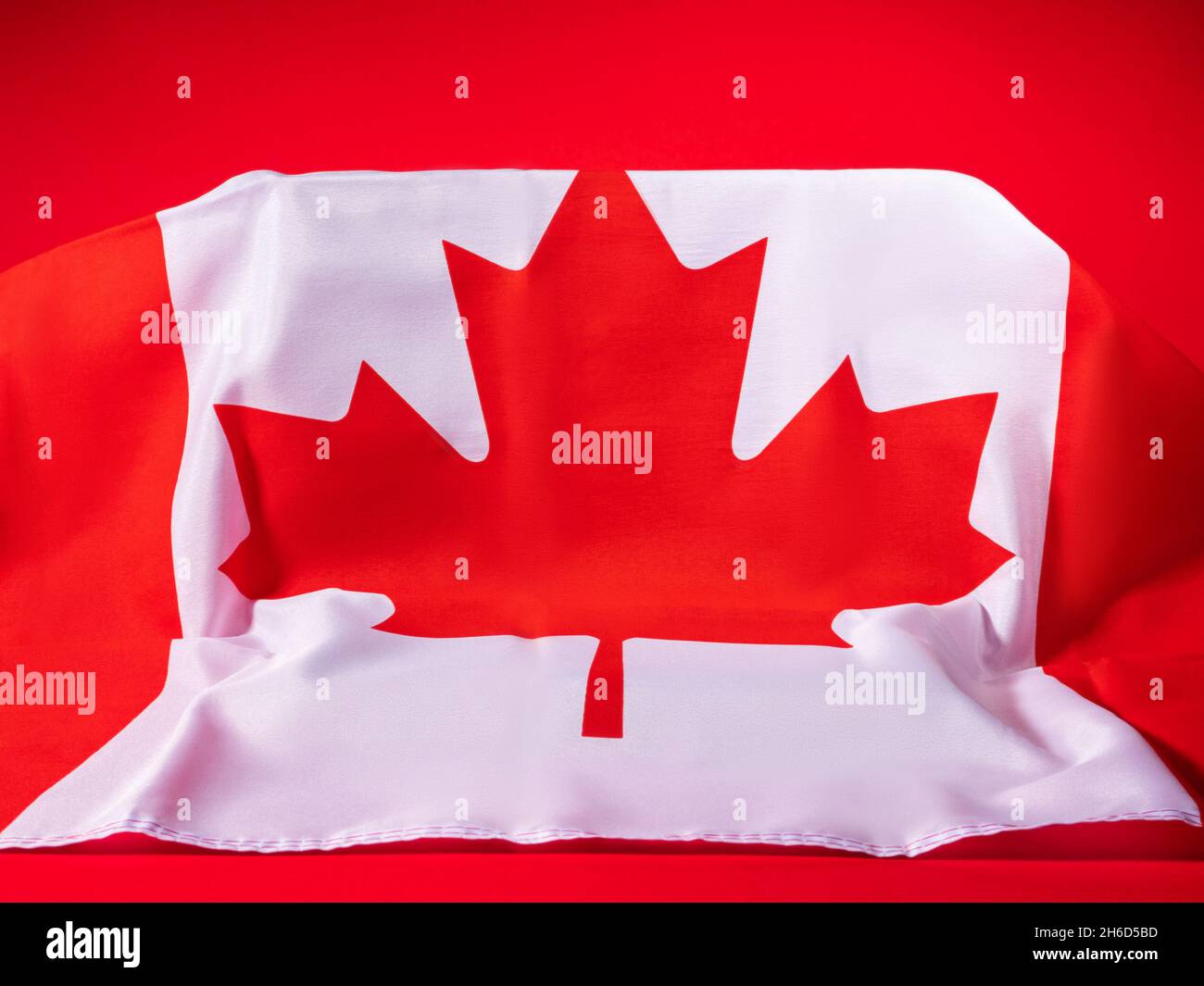 Canadian maple leaf flag on podium on red podium background Stock Photo ...