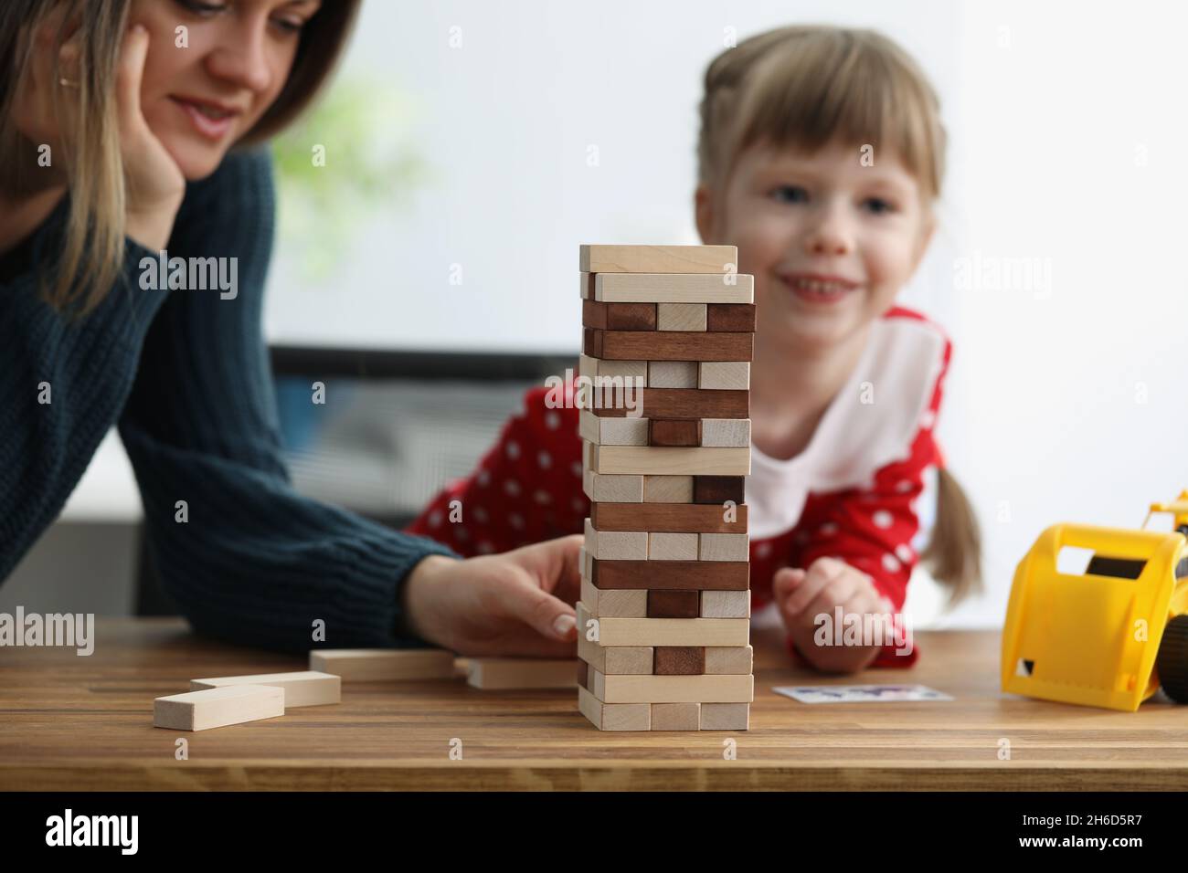 Happy mother with child girl playing wooden blocks tower at home Stock ...