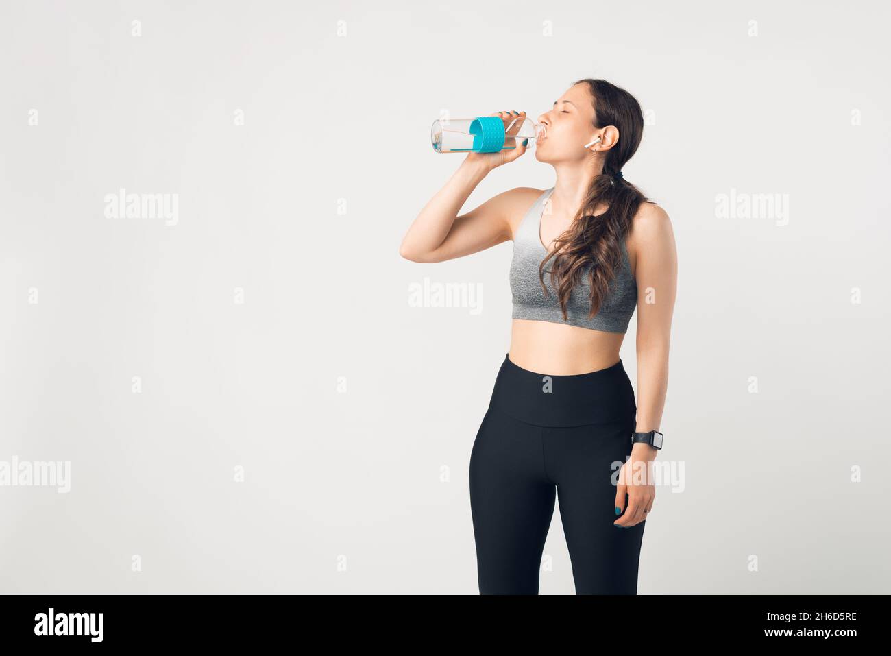 Photo of young woman hydrating over white wall Stock Photo - Alamy