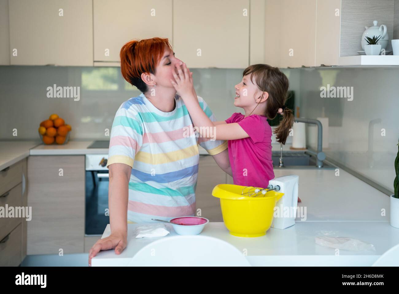 Funny little girl helper playing with dough on his hands learning to ...