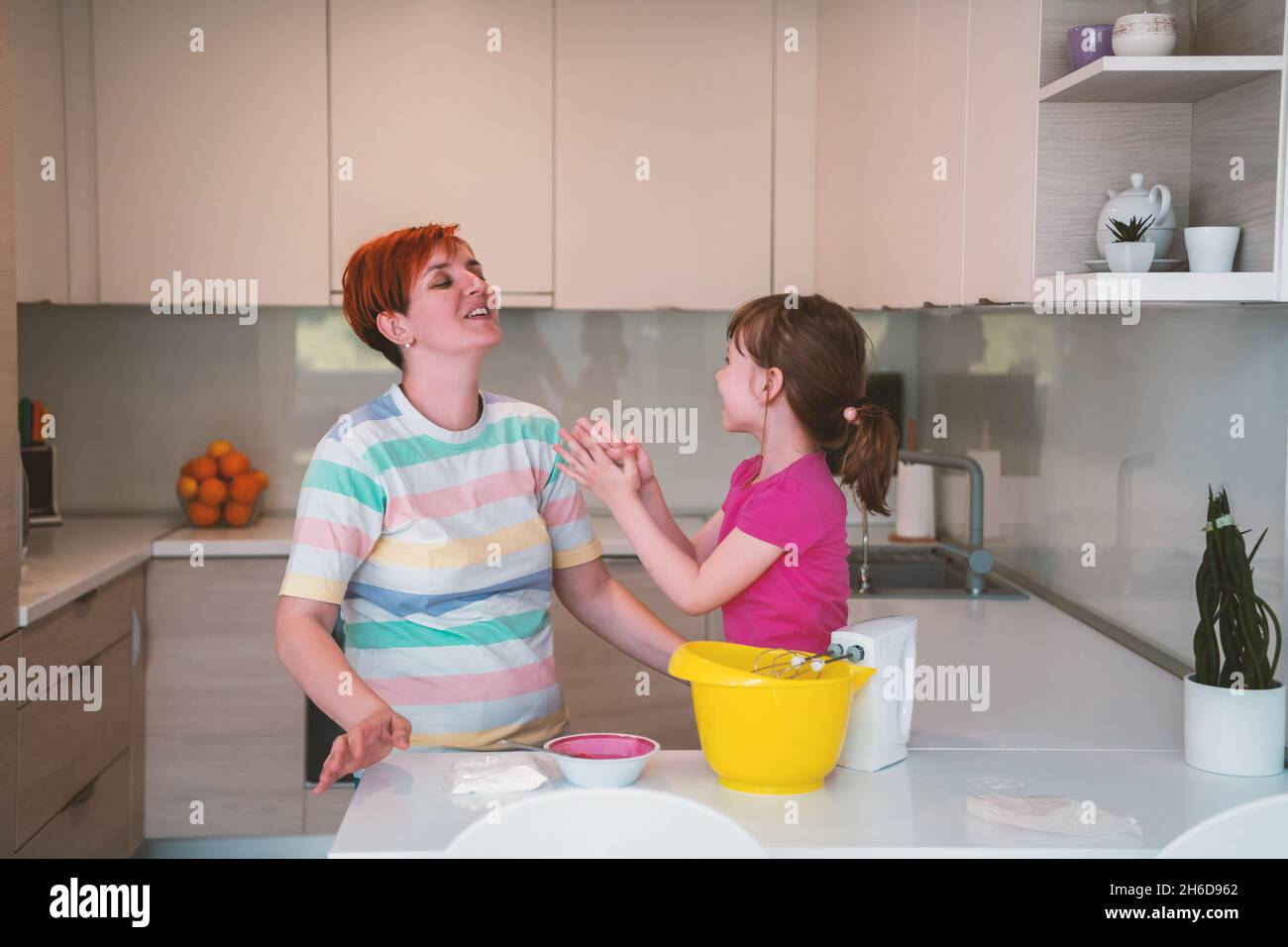 Funny little girl helper playing with dough on his hands learning to ...