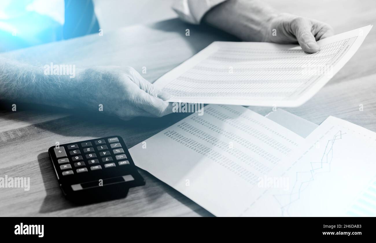 Hands of accountant checking financial document; light effect Stock ...