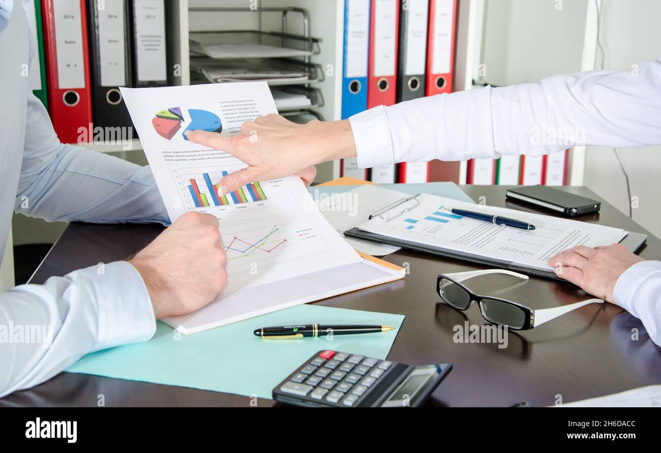 Two business people analyzing charts Stock Photo - Alamy
