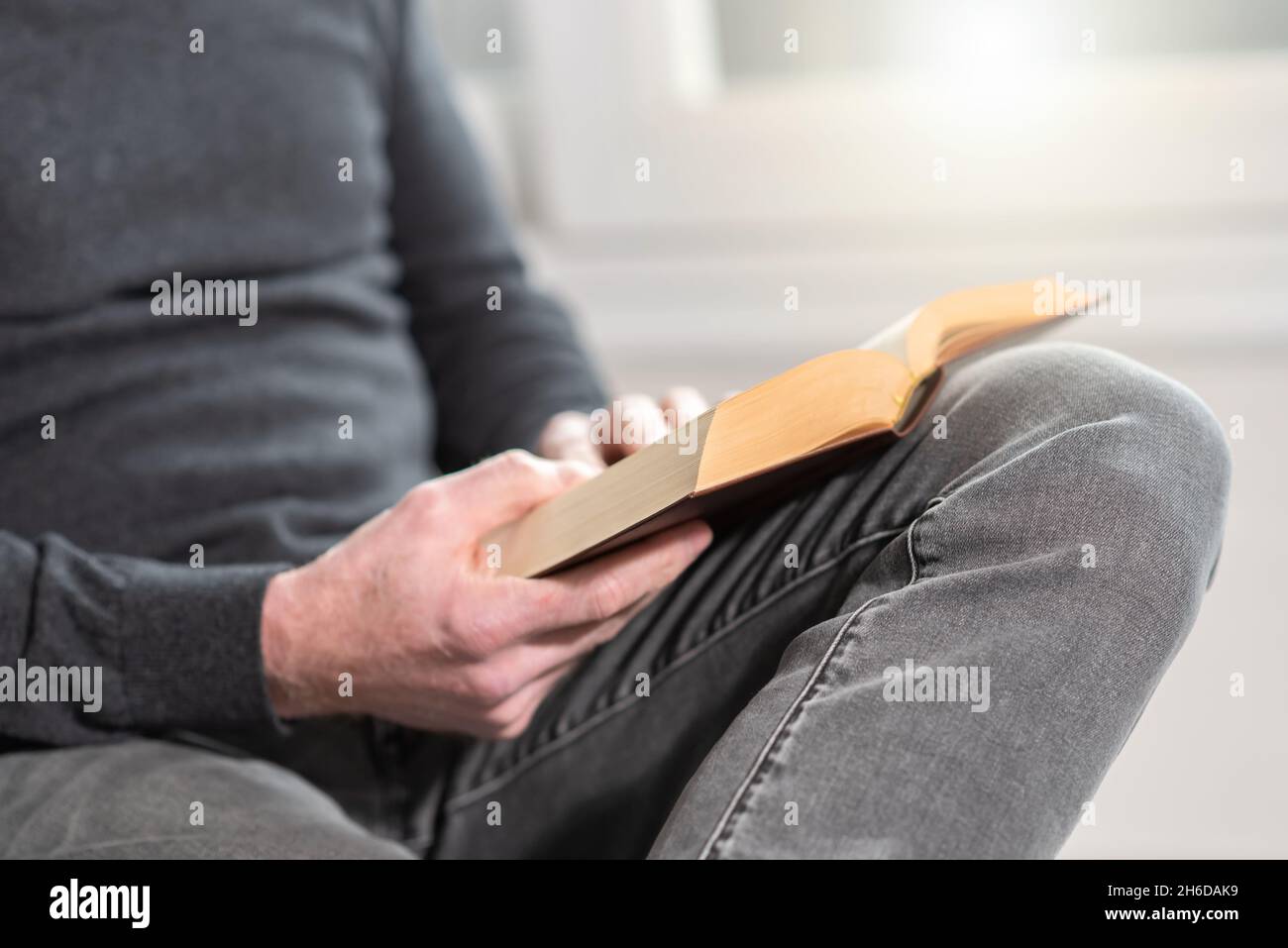Man sitting and reading a book Stock Photo - Alamy
