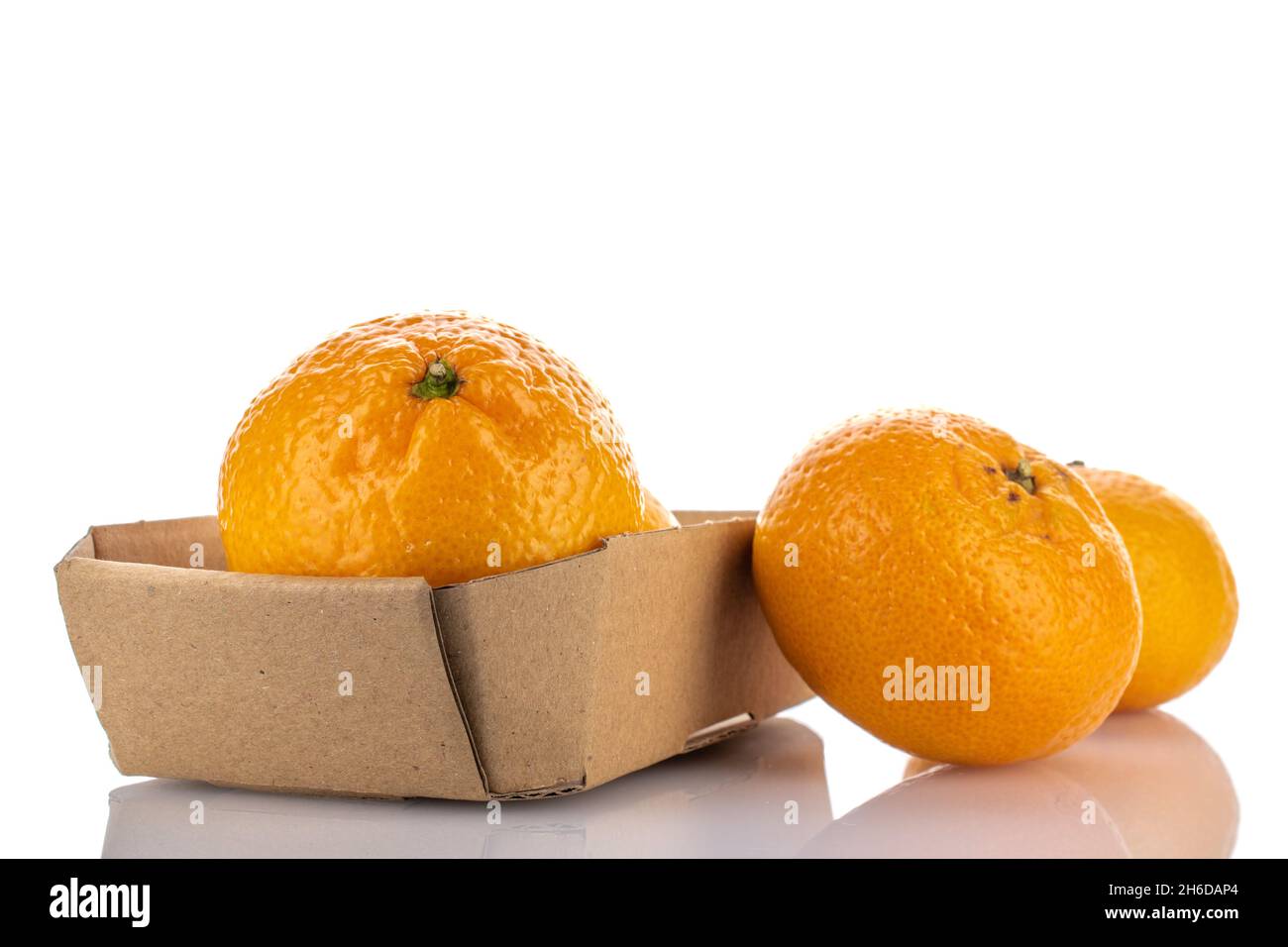 Three juicy tangerines with a paper box, close-up, isolated on white ...