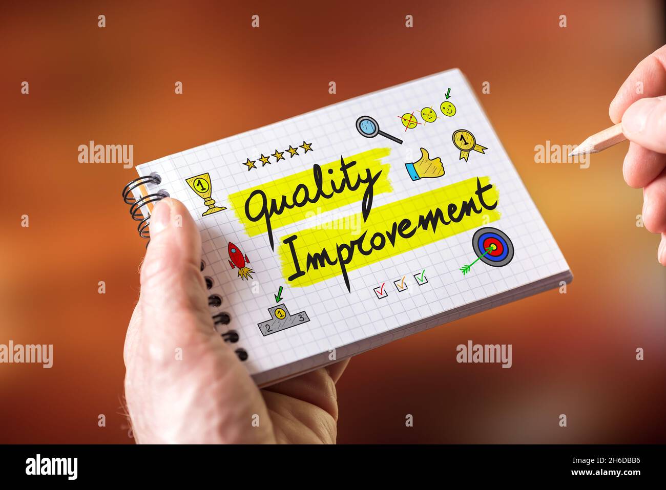 Hand drawing quality improvement concept on a notepad Stock Photo - Alamy