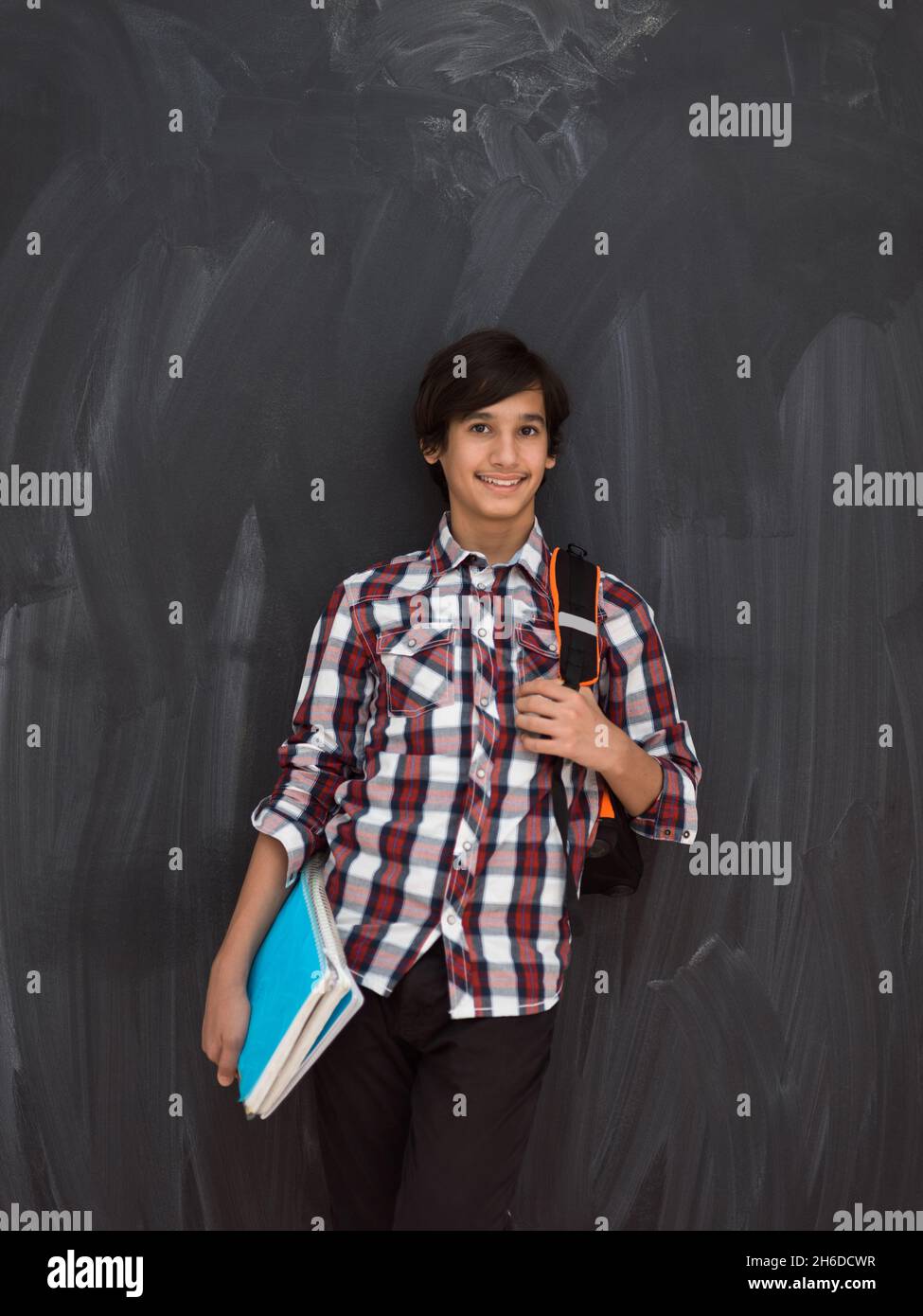 arab teenager with backpack wearing casual school look against black ...