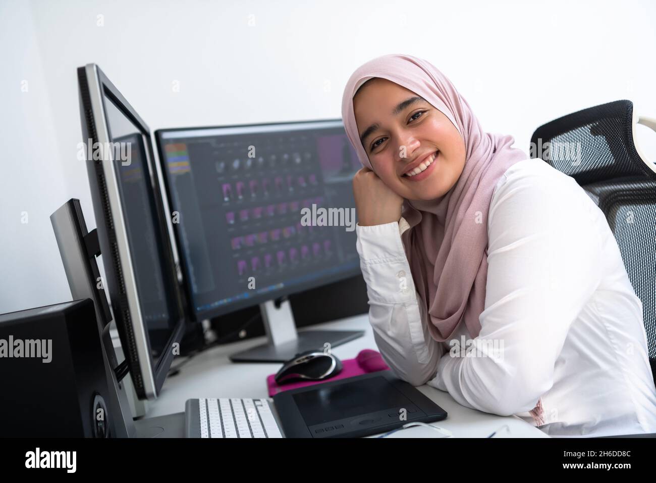 Female Arabic creative professional working at home office on desktop ...