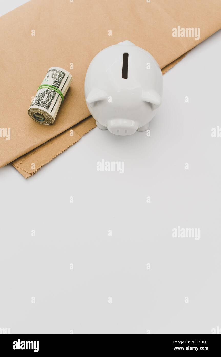 banknotes and white still bank on a folded brown paper bag on a white ...