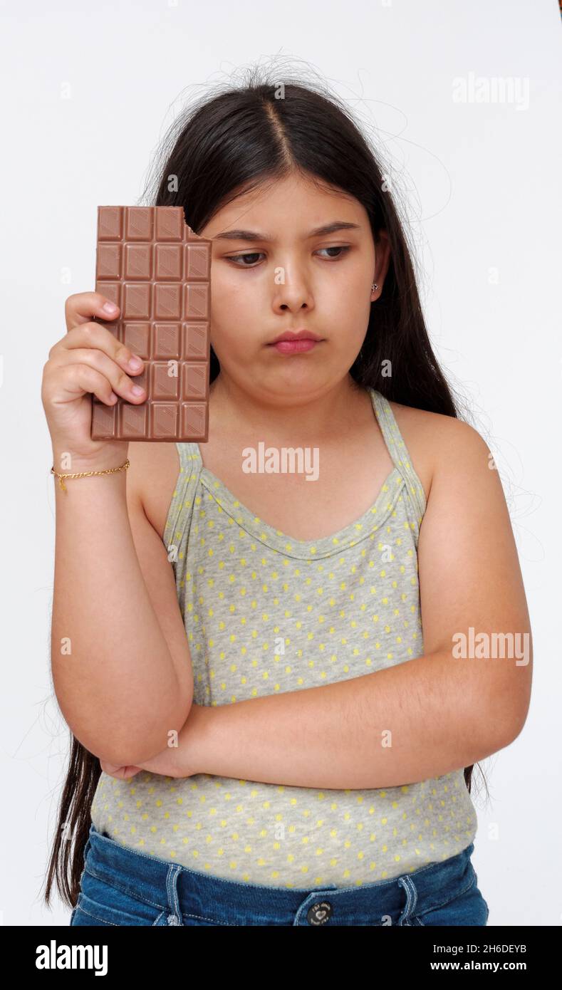 Chubby girl with a bar of chocolate Stock Photo - Alamy
