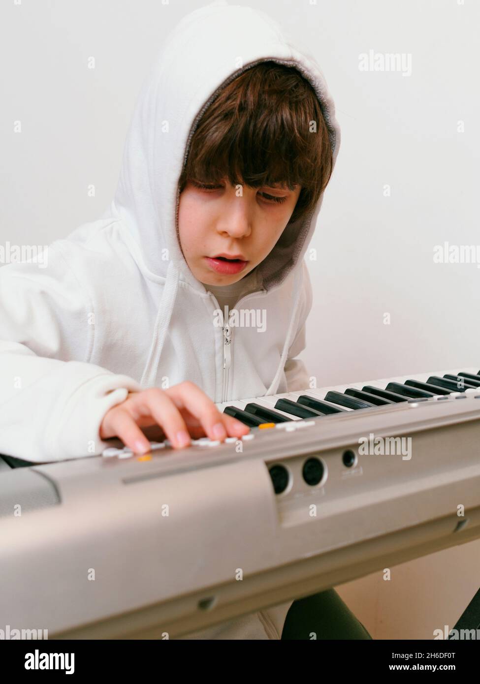 young boy of seven produces music on a Synthesizer keyboard Stock Photo ...