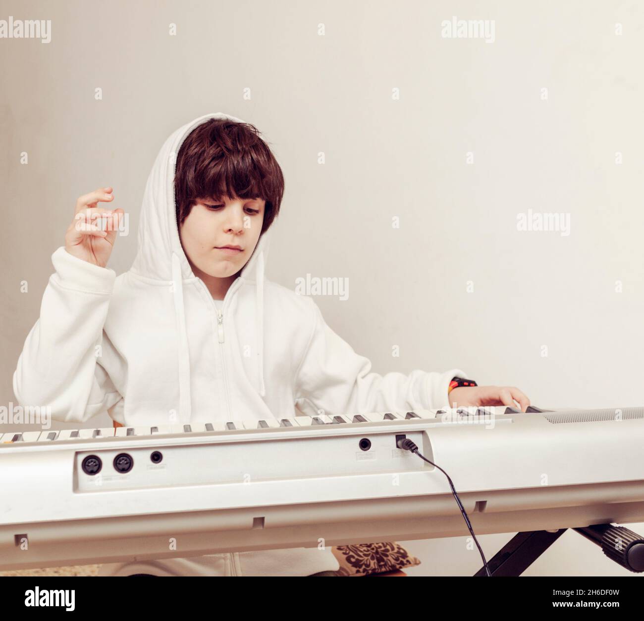 young boy of seven produces music on a Synthesizer keyboard Stock Photo ...