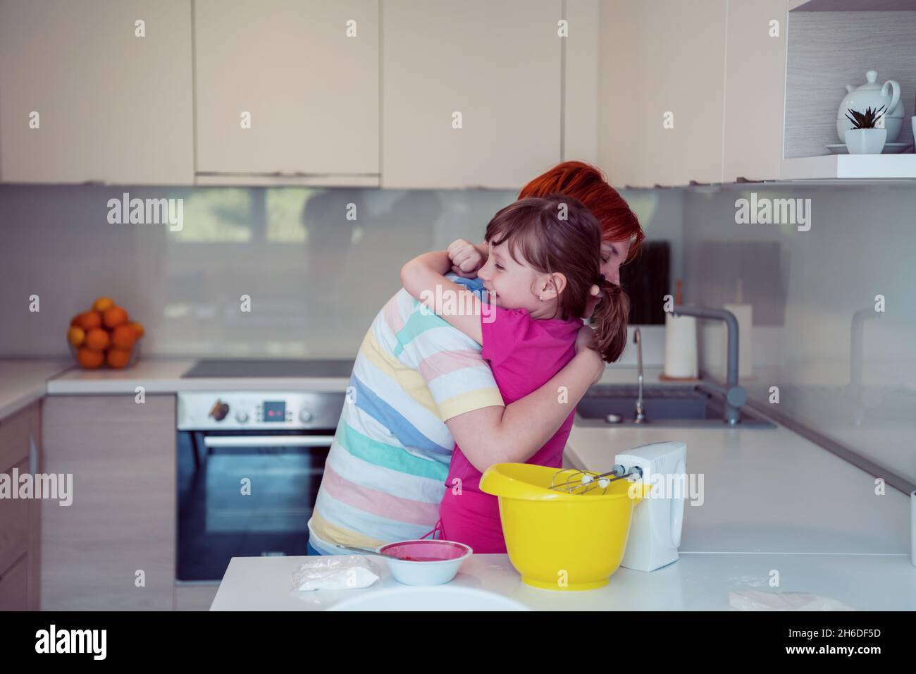 Funny little girl helper playing with dough on his hands learning to ...