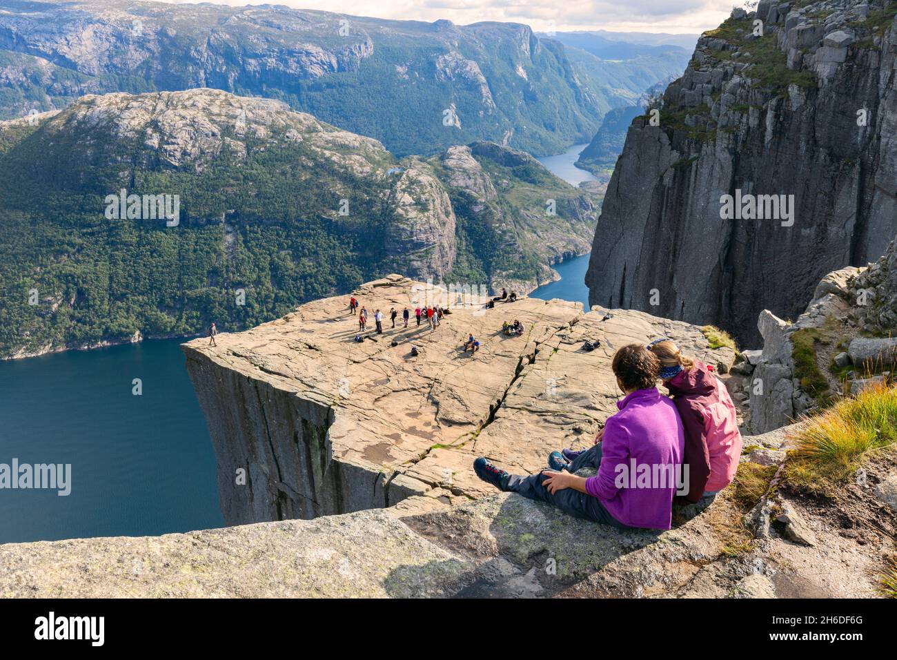 Couple sitting on a rock and admiring a view on Preikestolen. Aerial ...