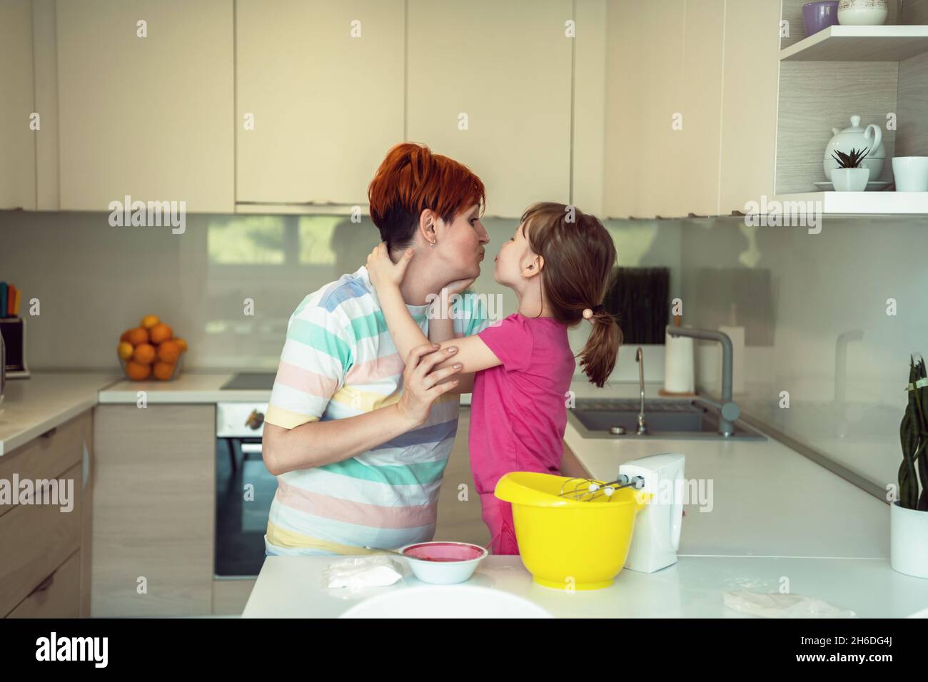 Funny little girl helper playing with dough on his hands learning to ...