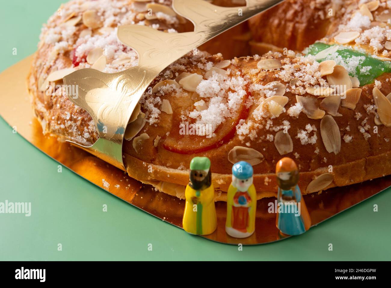Spanish typical epiphany cake "Roscon de Reyes" on green background ...