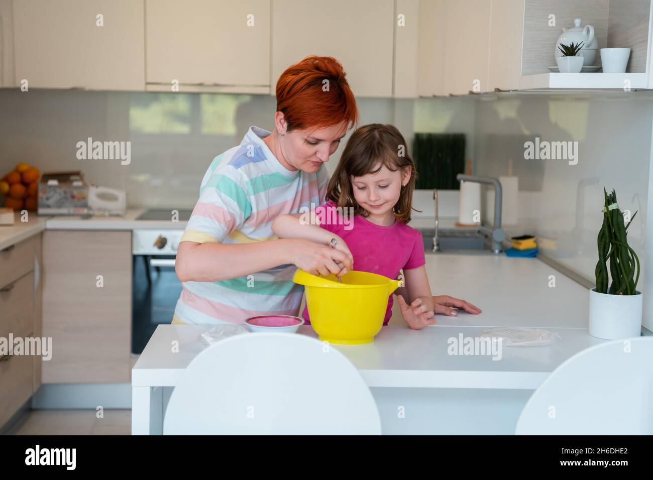 Funny little girl helper playing with dough on his hands learning to ...