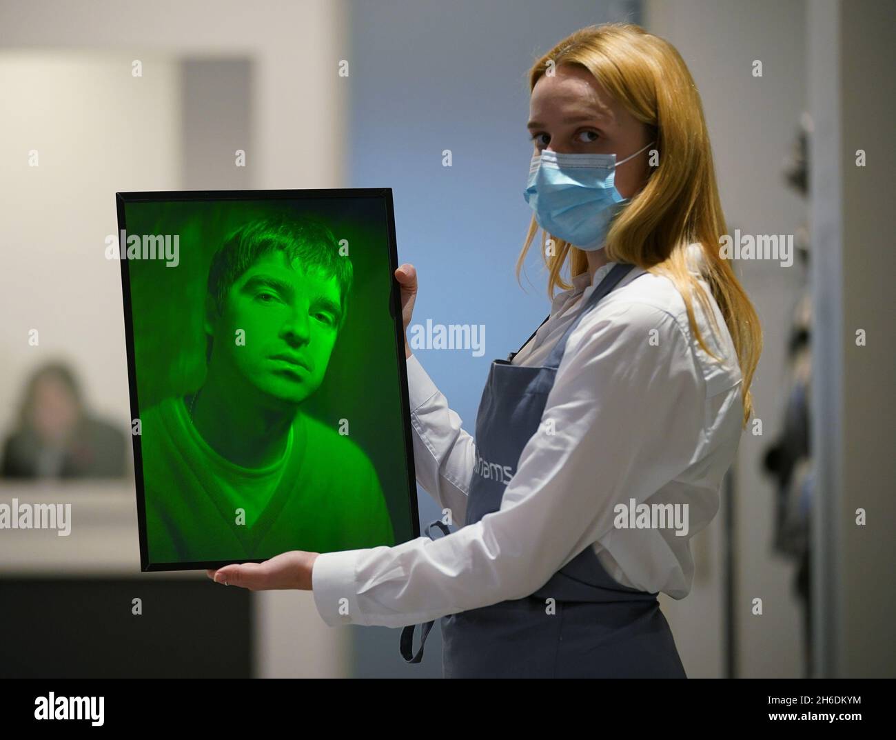 A Bonhams member of staff holds a glass plate white light reflection ...