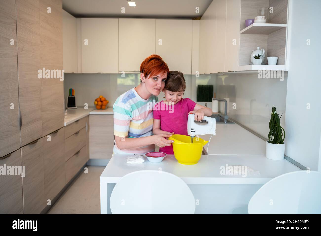 Funny little girl helper playing with dough on his hands learning to ...