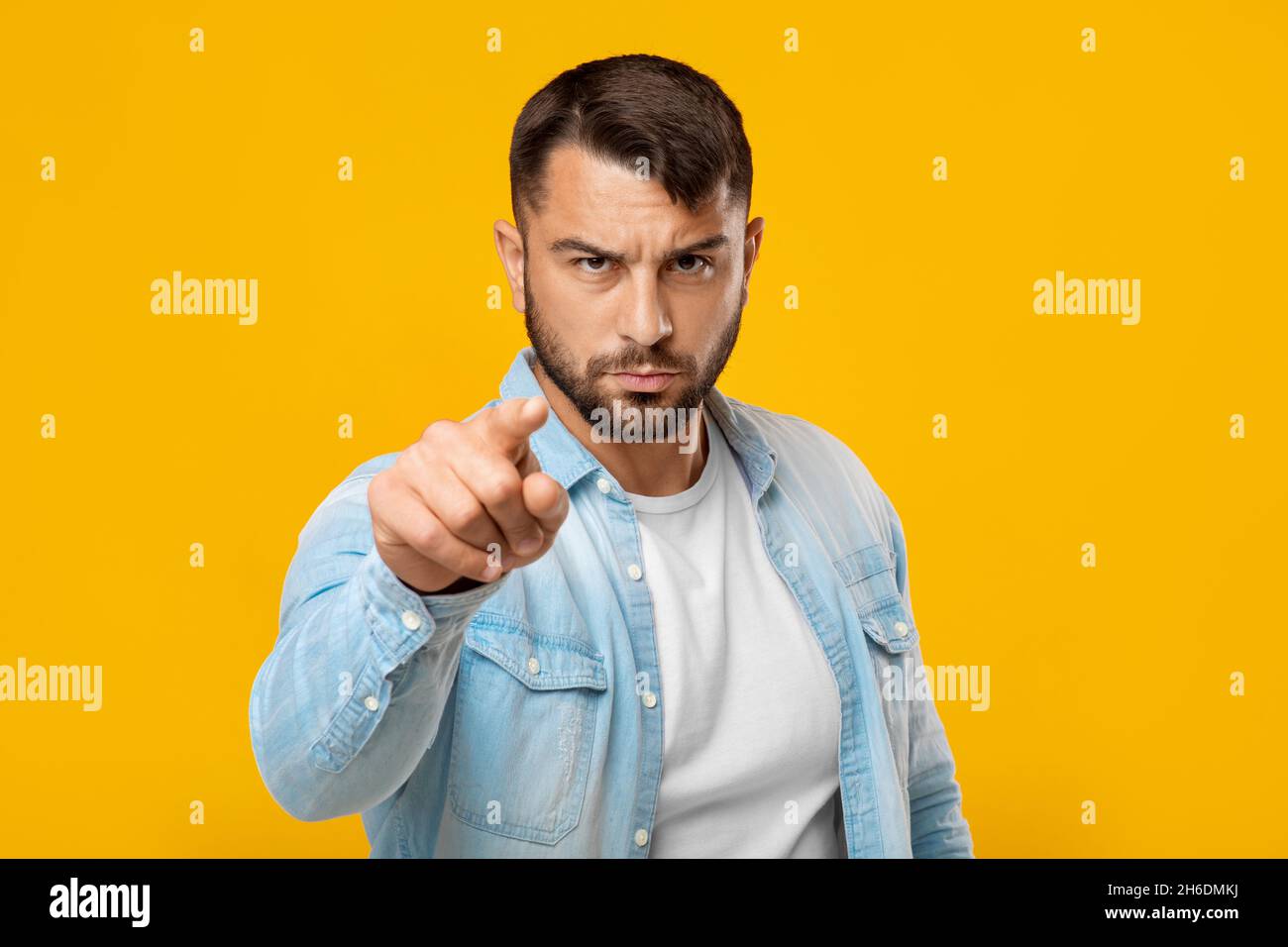 Serious strict sad adult european man with beard shows finger to camera ...