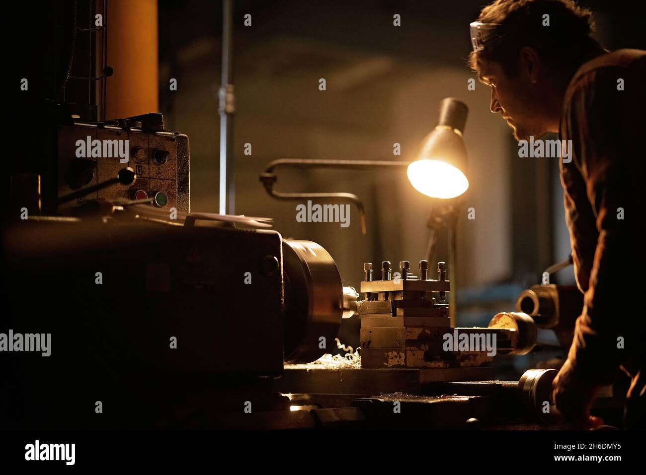 Industrial man working indoors in metal workshop at night Stock Photo ...