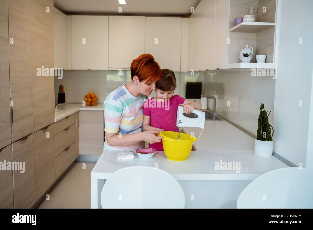 Funny little girl helper playing with dough on his hands learning to ...