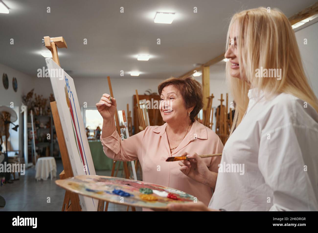 Positive delighted females looking at abstract picture Stock Photo - Alamy