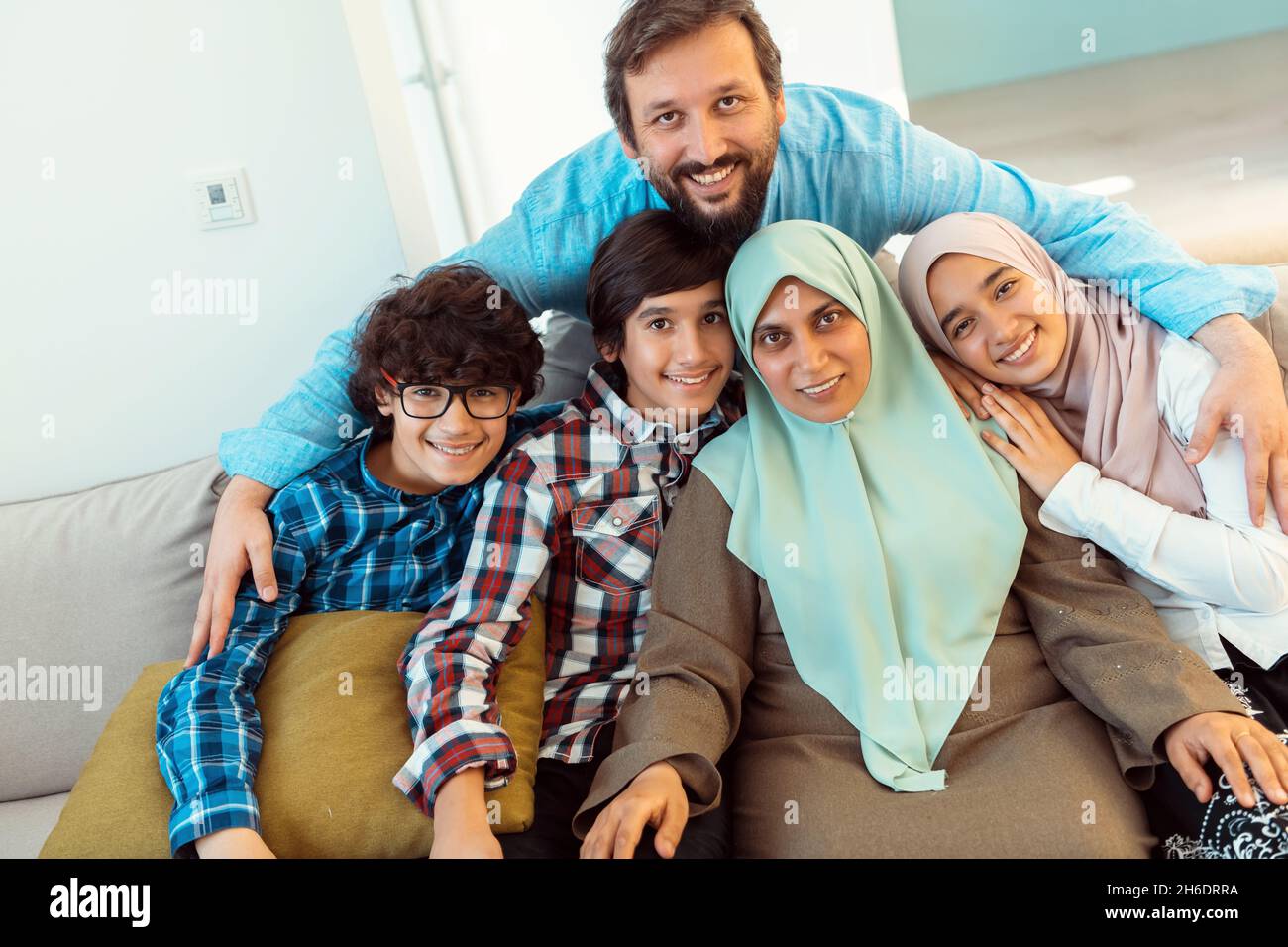 Portrait photo of an arab muslim family sitting on a couch in the ...