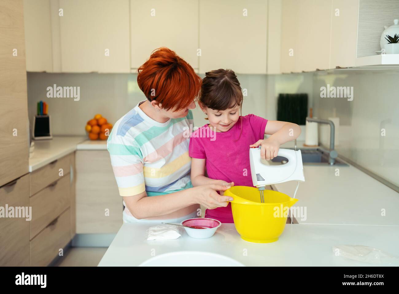 Funny little girl helper playing with dough on his hands learning to ...