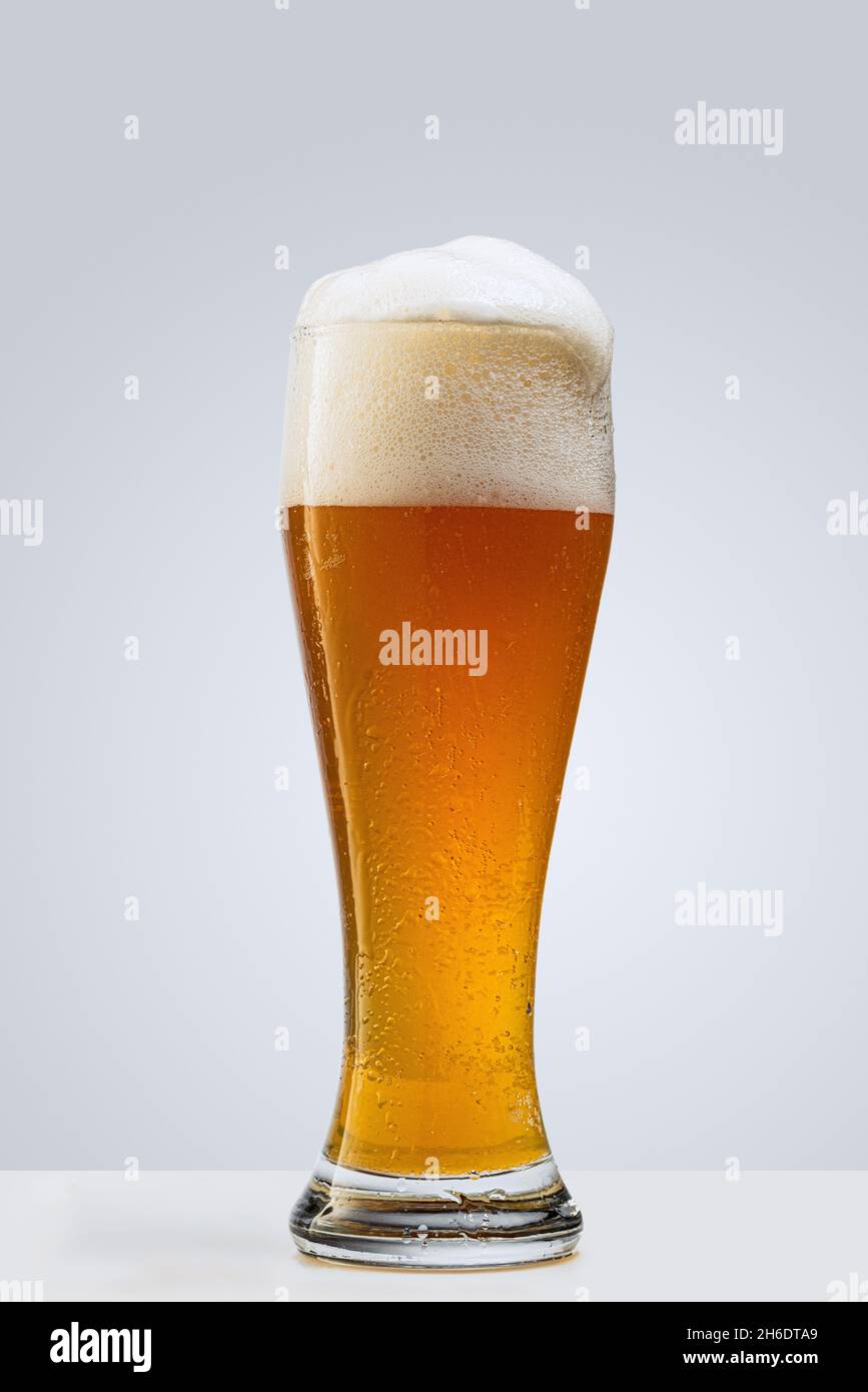 Glass of lager foamy beer isolated over gray background. Concept of ...