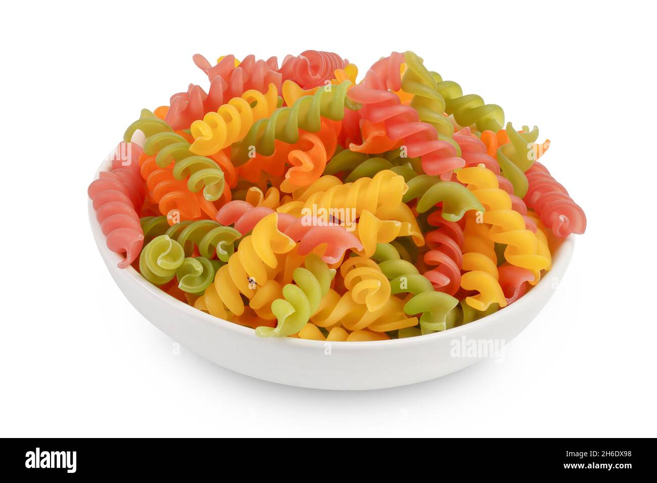raw Fusilli in ceramic bowl colored pasta, isolated on white background ...