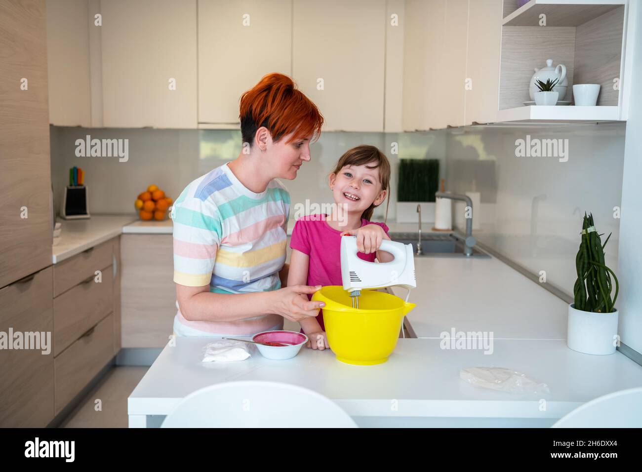 Funny little girl helper playing with dough on his hands learning to ...