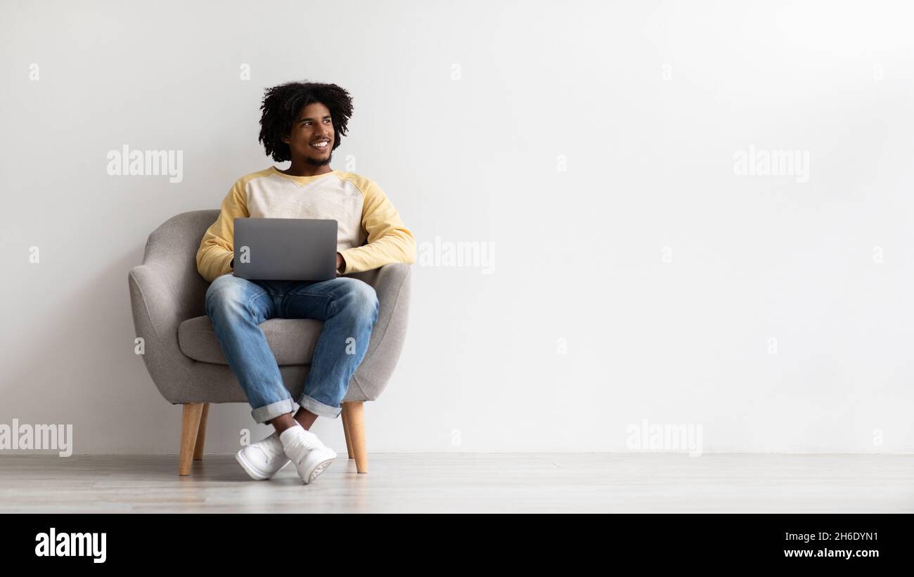 Smiling Black Guy With Laptop Computer Sitting In Chair And Looking ...