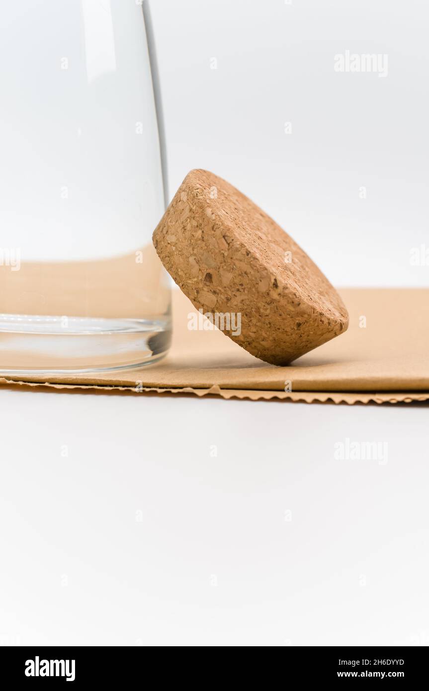 glass carafe with fresh water and cork lid on a white and brown paper ...