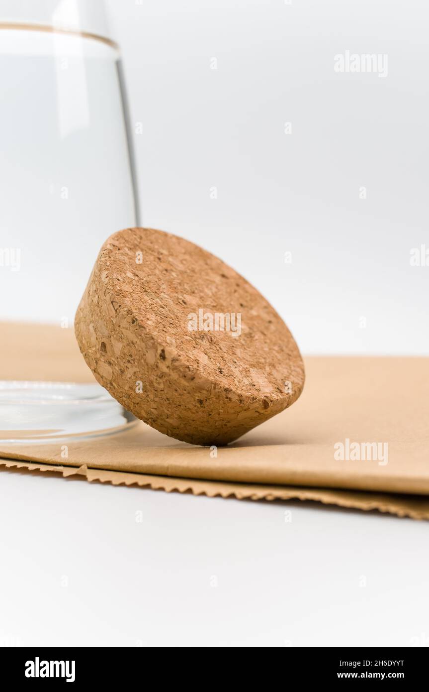 glass carafe with fresh water and cork lid on a white and brown paper ...