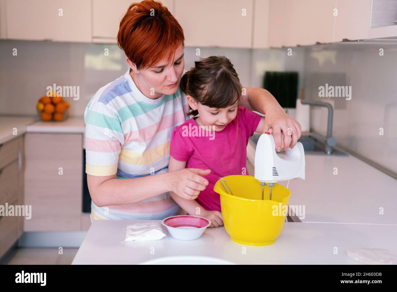 Funny little girl helper playing with dough on his hands learning to ...