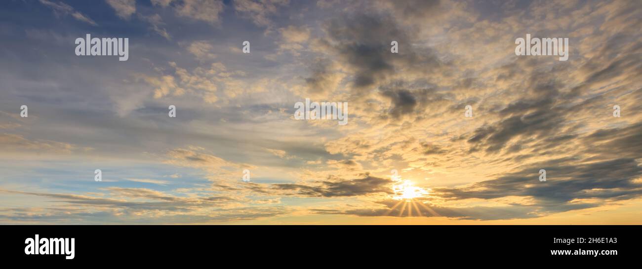 Colorful dramatic clouds lit by a sun against the sunset or sunrise sky ...
