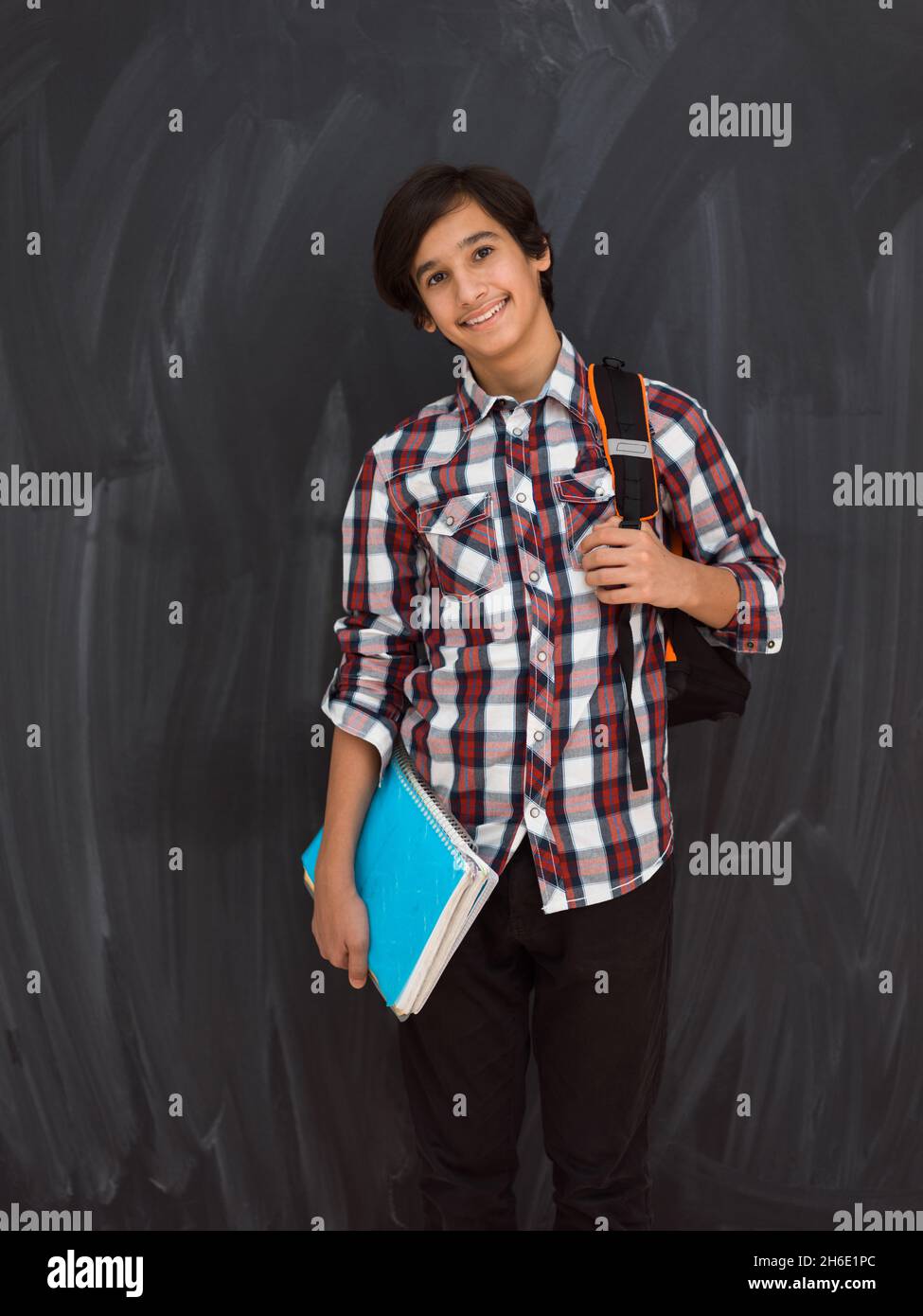 arab teenager with backpack wearing casual school look against black ...