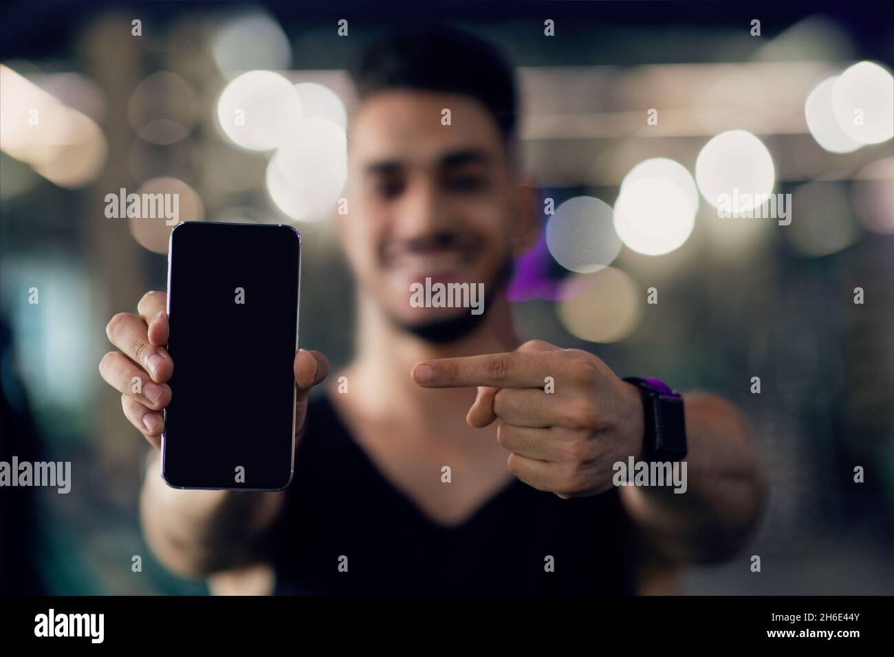 Mobile App. Smiling Arab Guy Pointing At Blank Smartphone With Black ...