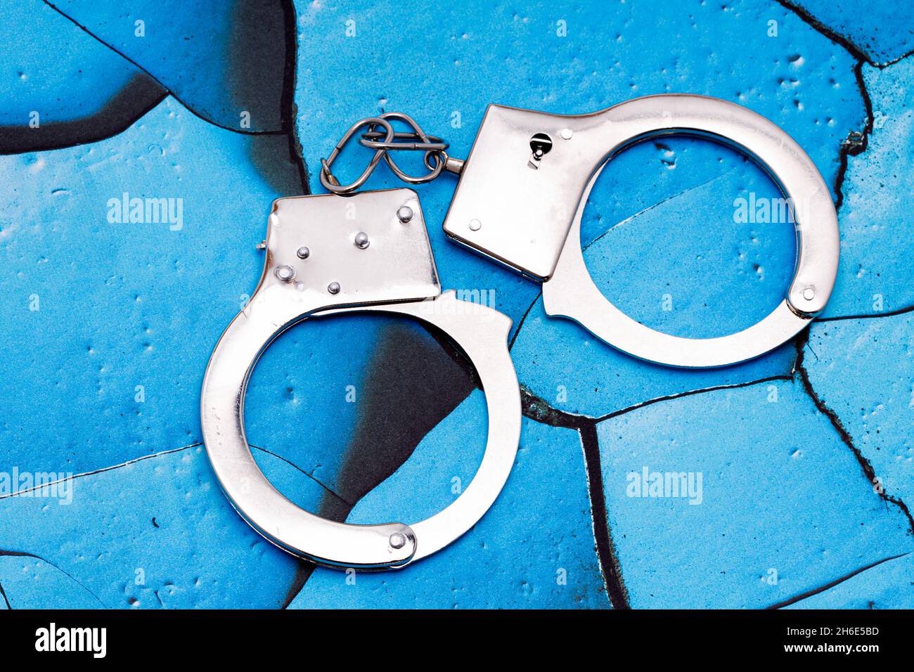 silver handcuffs on a stone blue texture with cracks. High quality ...