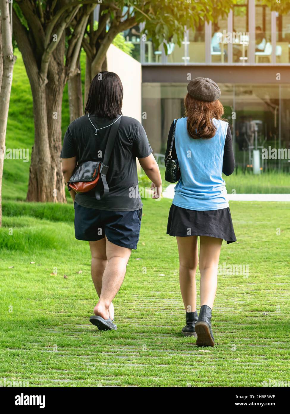 Back view of happiness female friends talking and walking along the ...