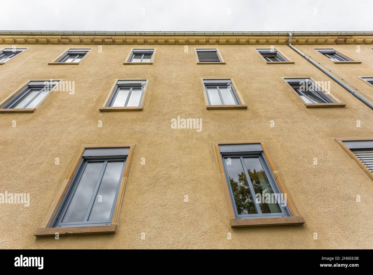 Low angle shot of a modern building with glass windows under a cloudy ...