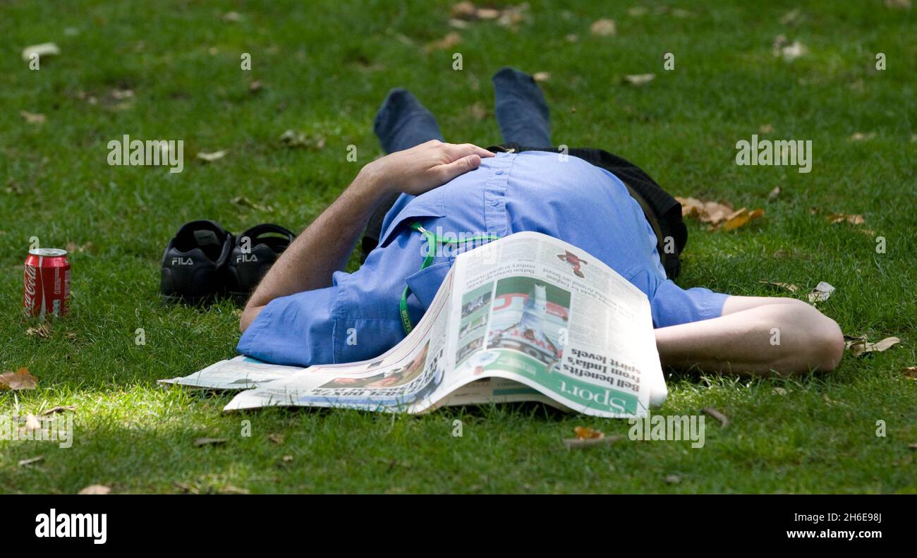 An office worker enjoys his lunch break in the sun in St James park in ...