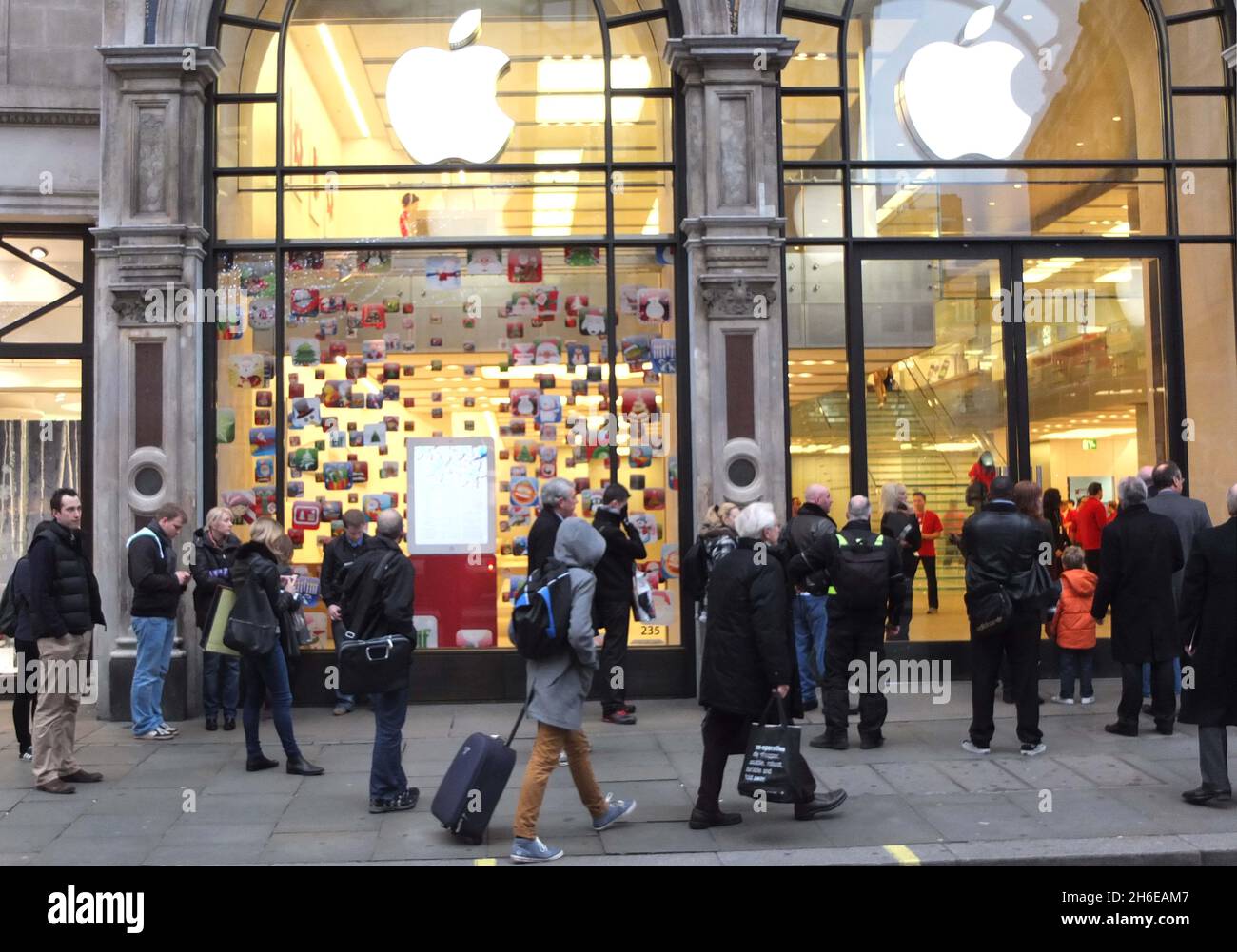 Last minute Christmas shoppers queue outside the Apple store on London ...